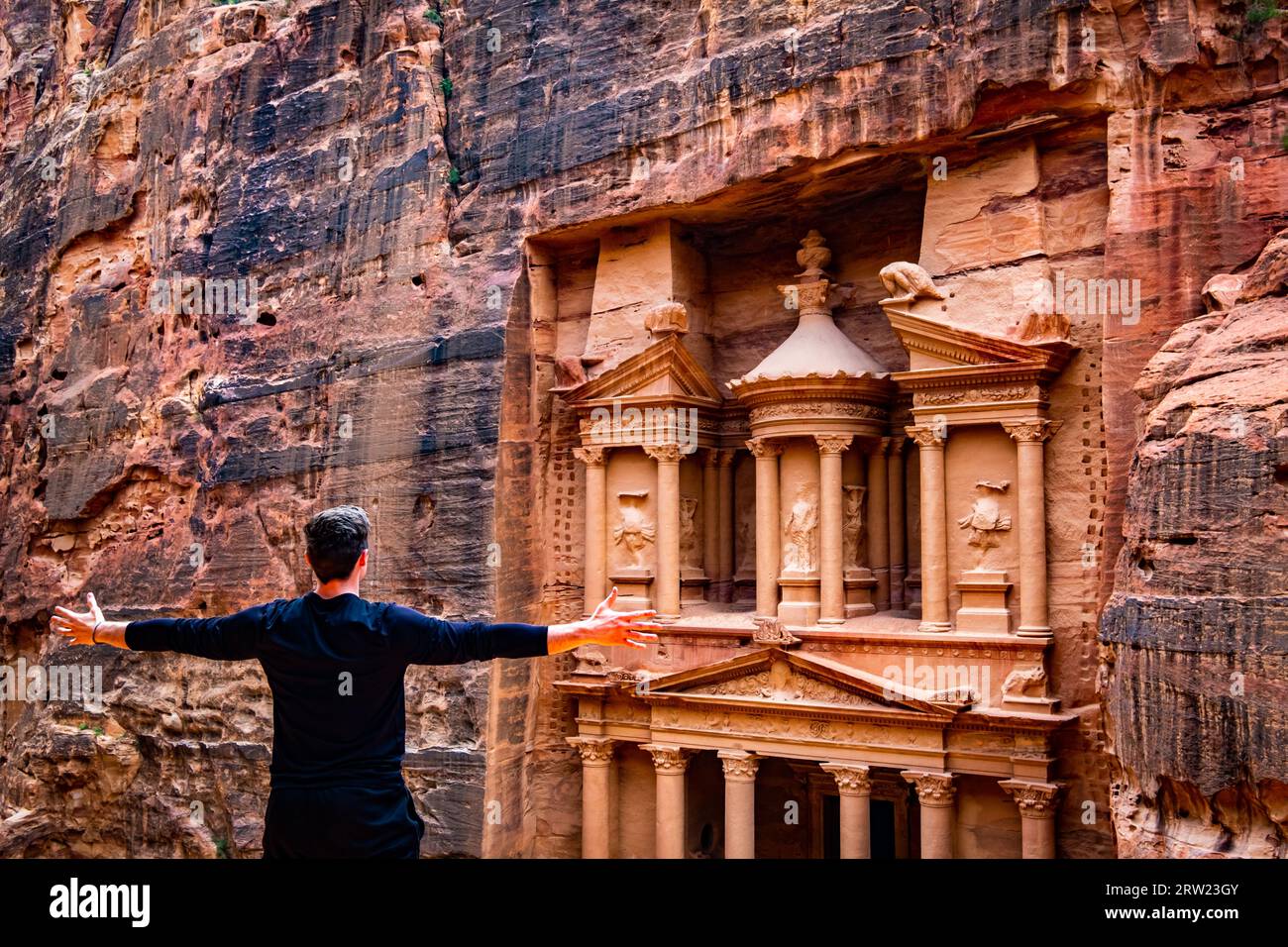 A man is posing in front of the monastery of Petra in the desert in ...