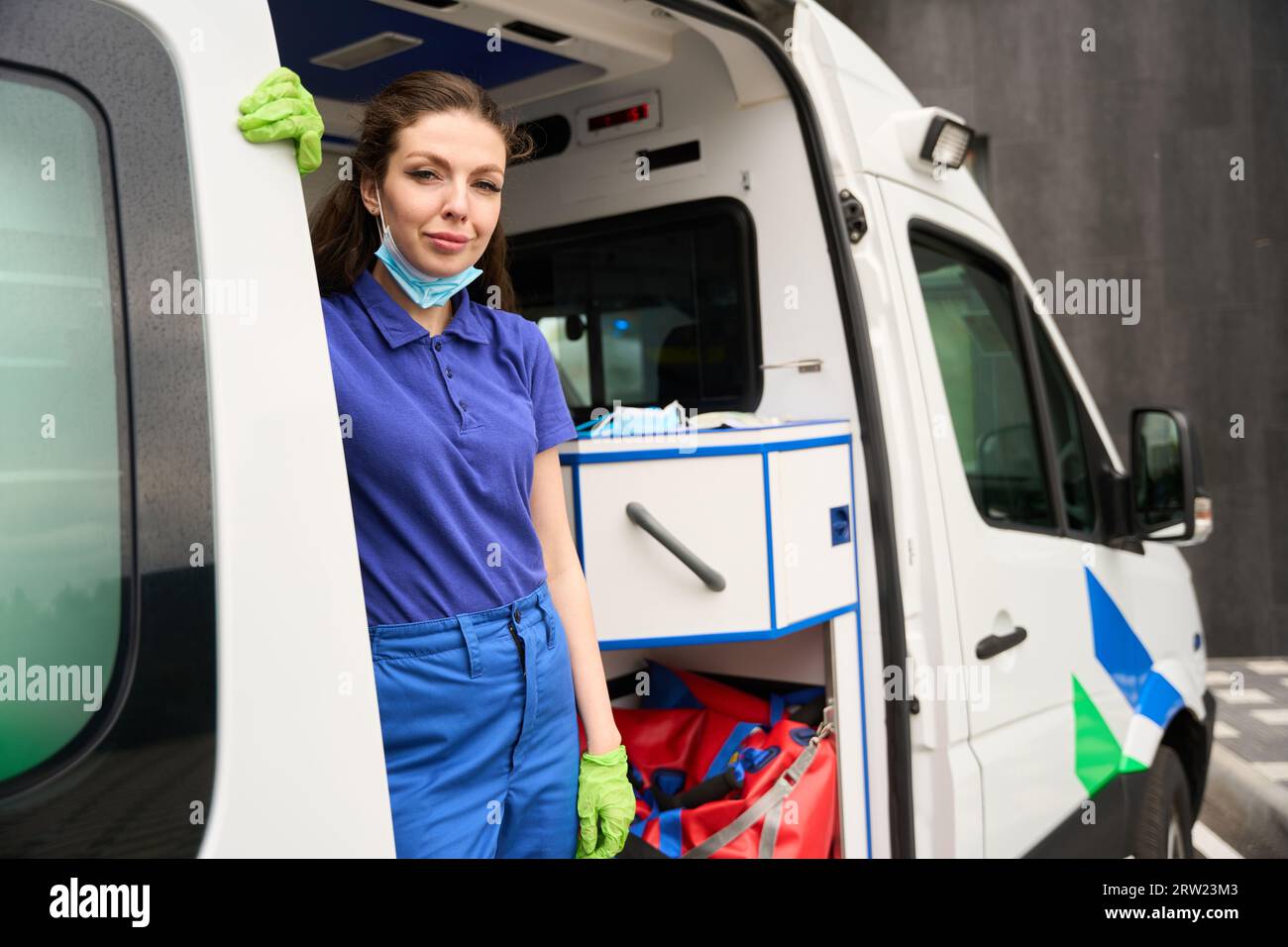Pretty female paramedic is in an ambulance near modern building Stock ...