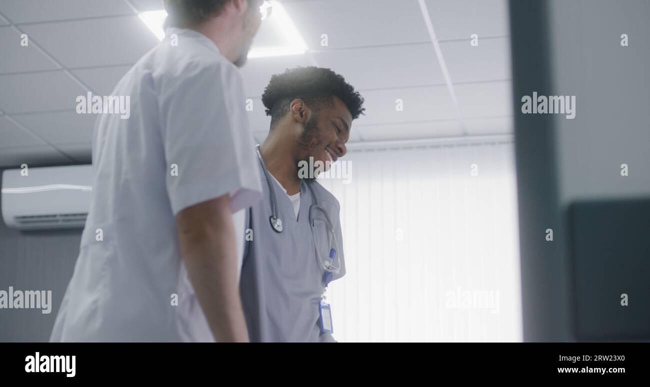Doctor calls lift in medical center corridor and listens to his African ...