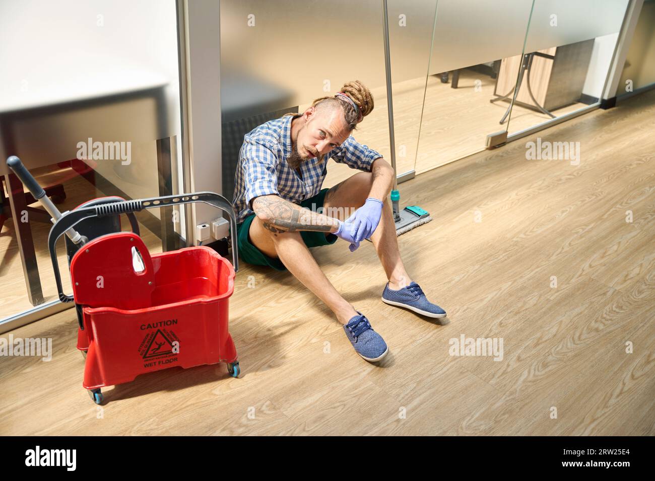 Young man sat down to rest on the floor Stock Photo - Alamy