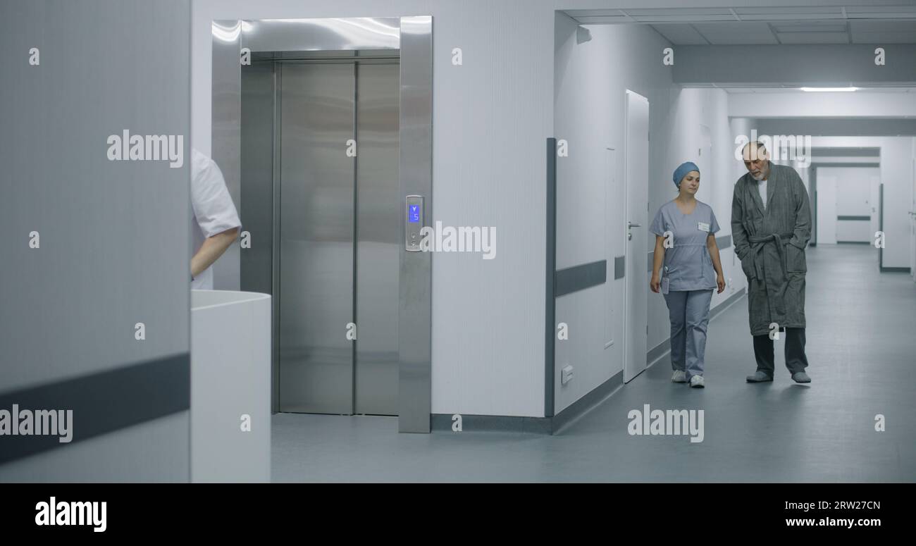 Nurse and senior patient go to elevator and call it. Elderly patient ...