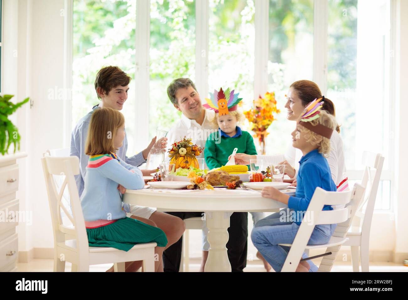Family with kids eating Thanksgiving dinner. Roasted turkey and pumpkin ...
