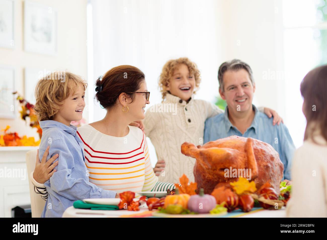 Family at Thanksgiving dinner. Parents and kids enjoy roasted turkey ...