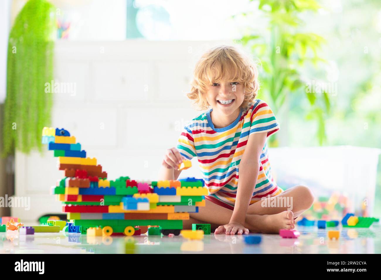 Kids play with colorful blocks. Little boy building tower at home or ...