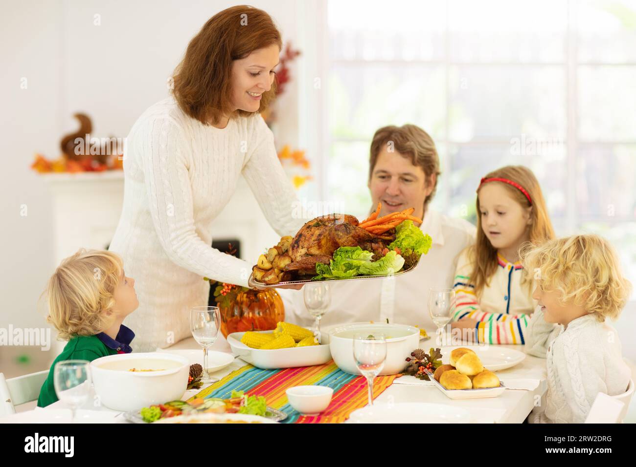 Family with kids eating Thanksgiving dinner. Roasted turkey and pumpkin ...