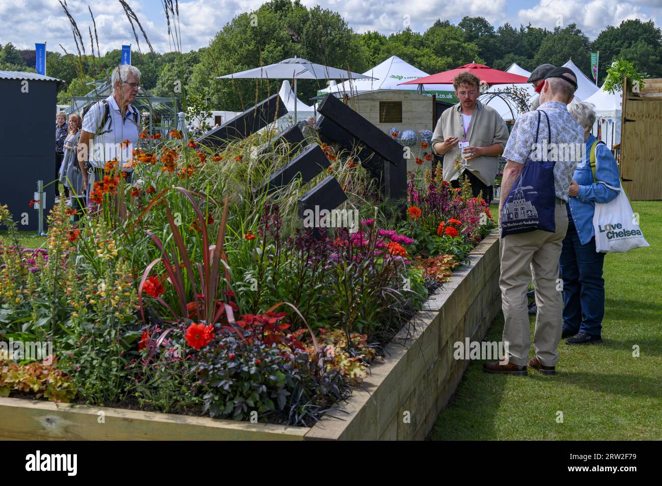 Visitors view colourful garden flowers - horticultural raised bed competition entry, RHS Tatton ...