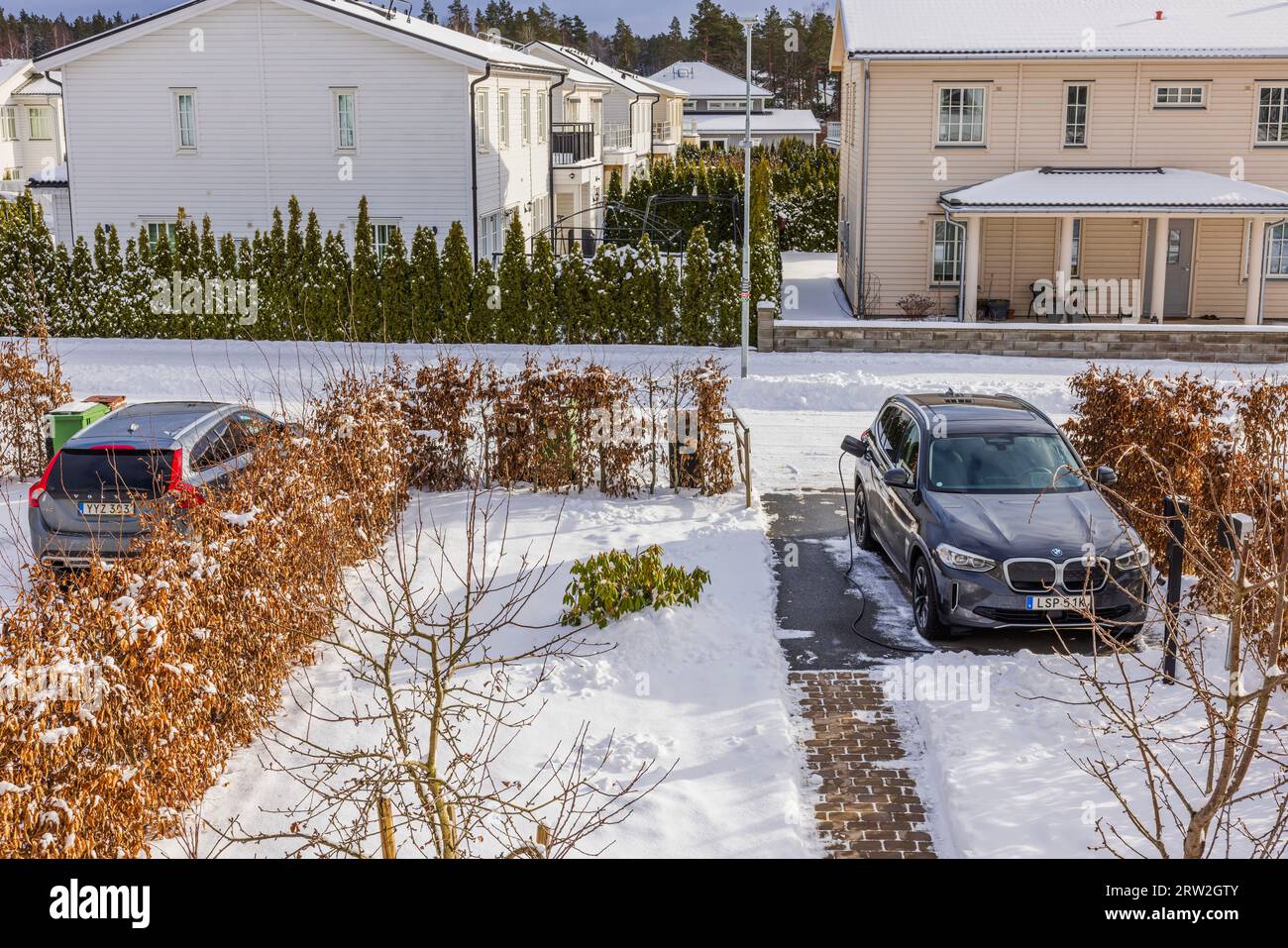 Beautiful winter view of modern village with cars parked in private ...