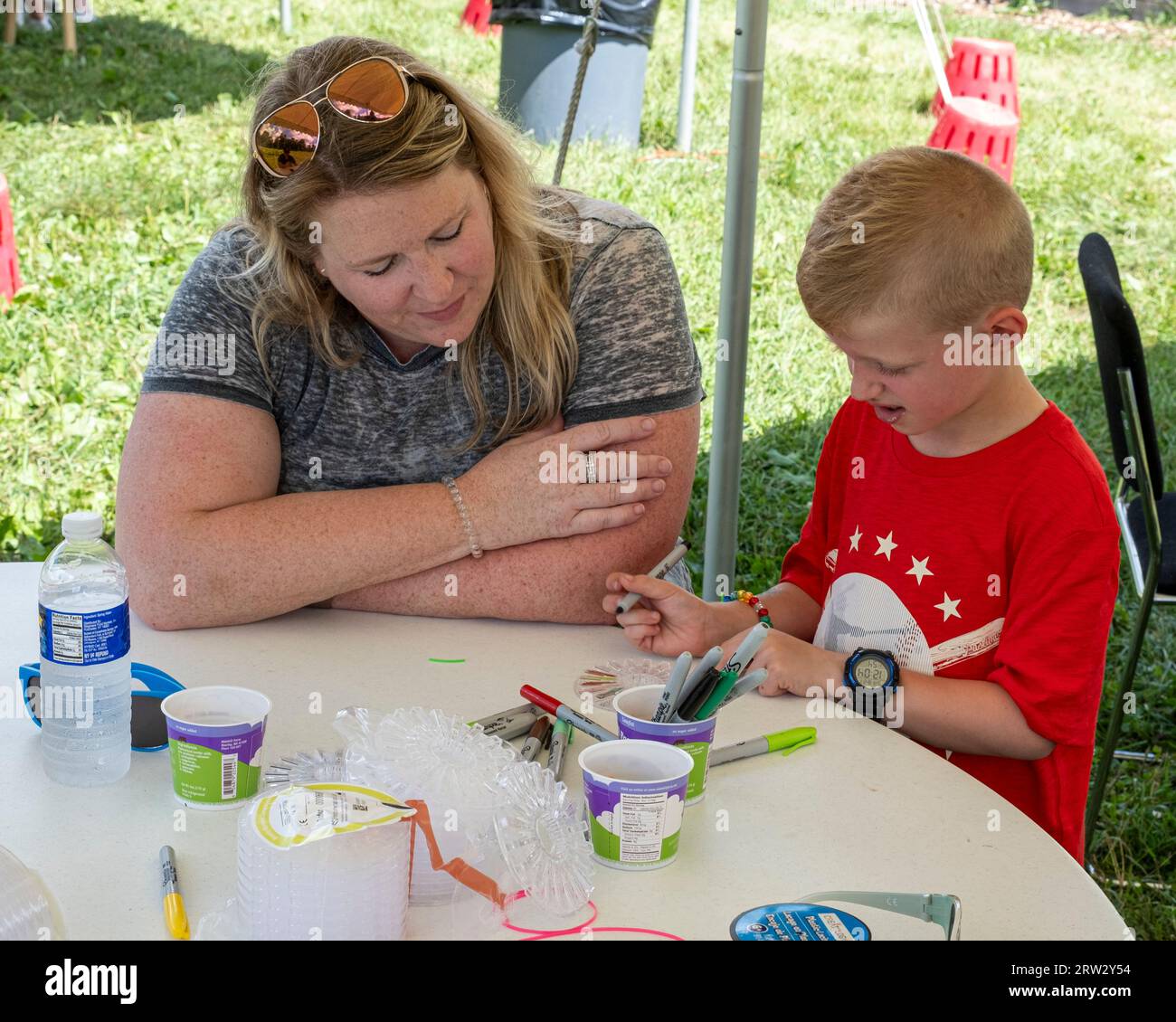 Mom watching her son draw outside Stock Photo - Alamy