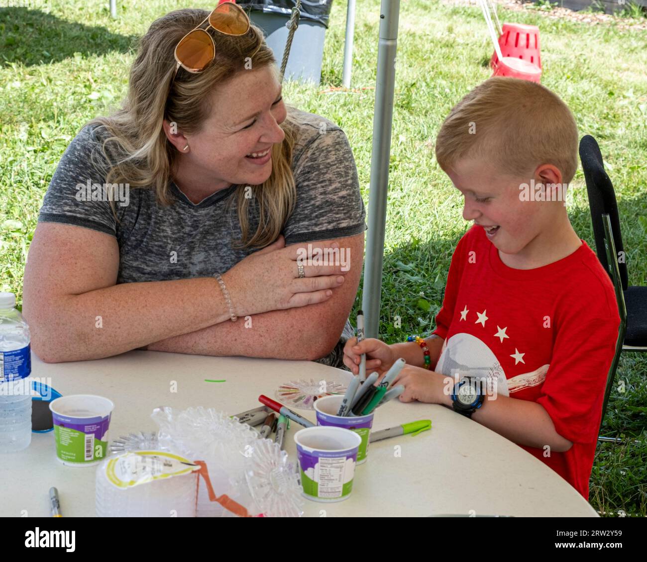 Mom watching her son draw outside Stock Photo - Alamy