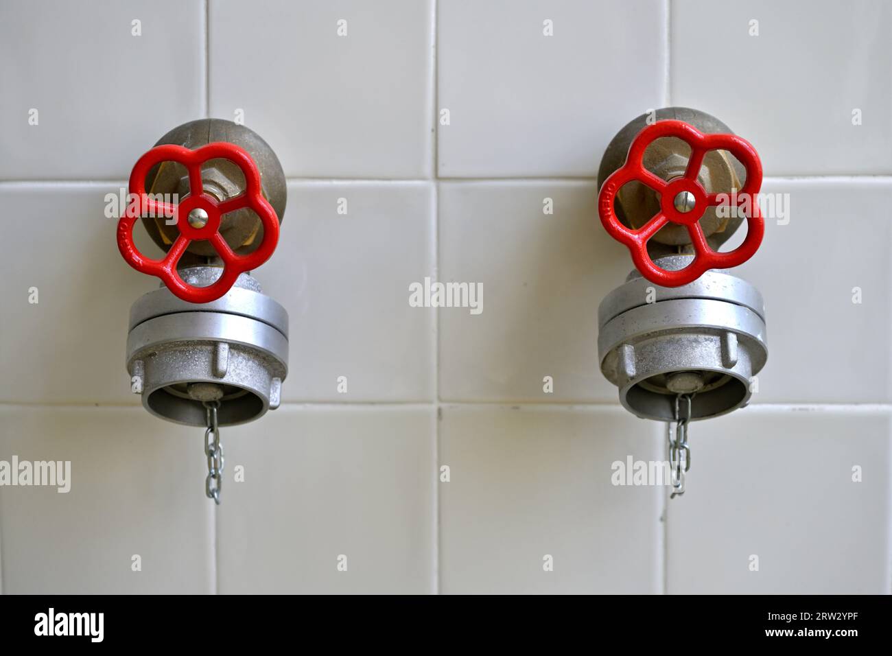 Two dry riser firefighting valves with red handles on white tiled ...