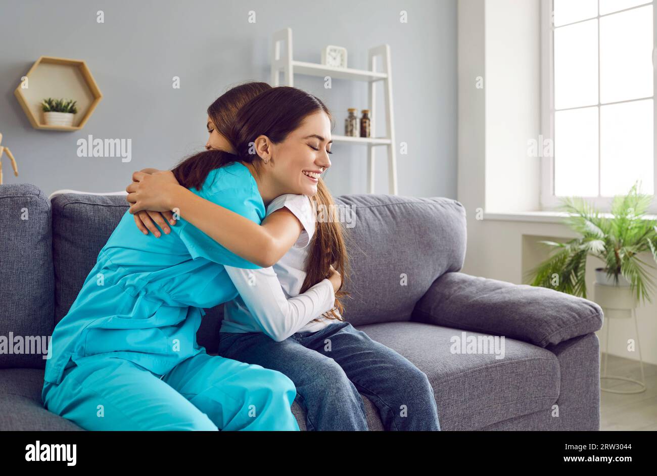 Portrait of a female friendly nurse with a child girl patient hugging ...