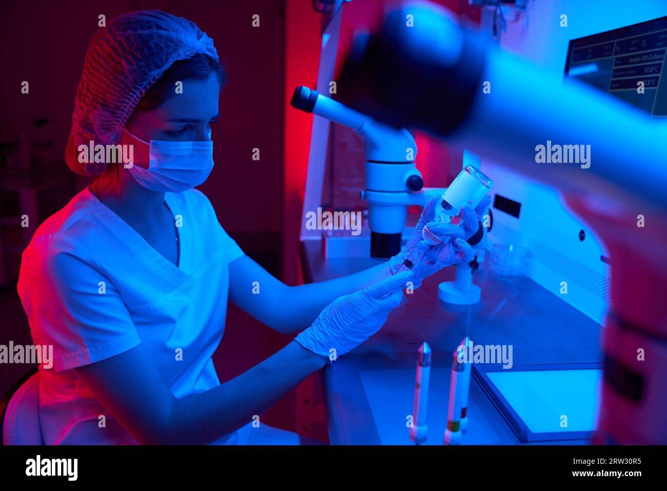 Embryologist conducts preparatory manipulations for the ICSI procedure ...