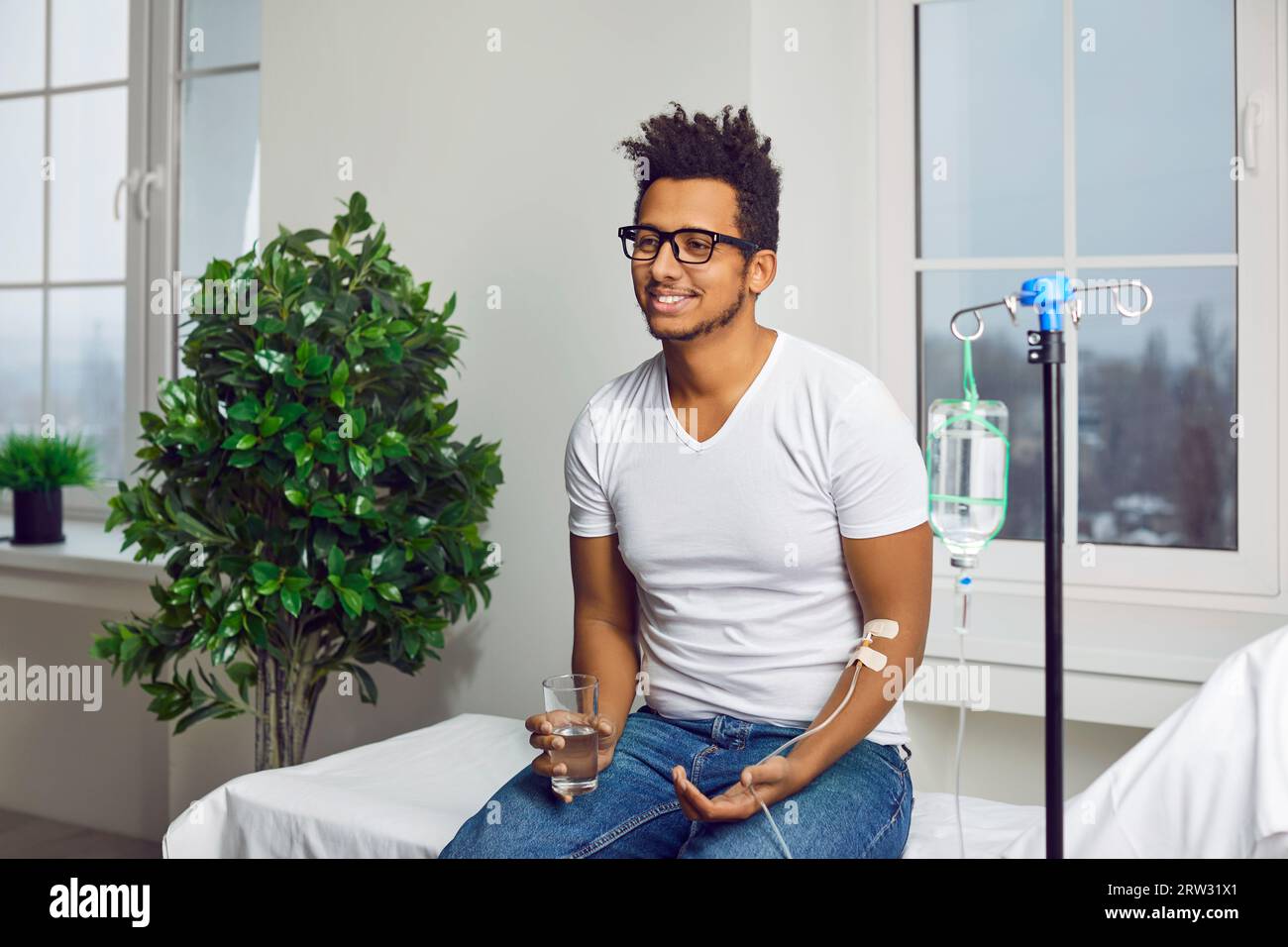 Happy young African American man receiving an intravenous vitamin ...