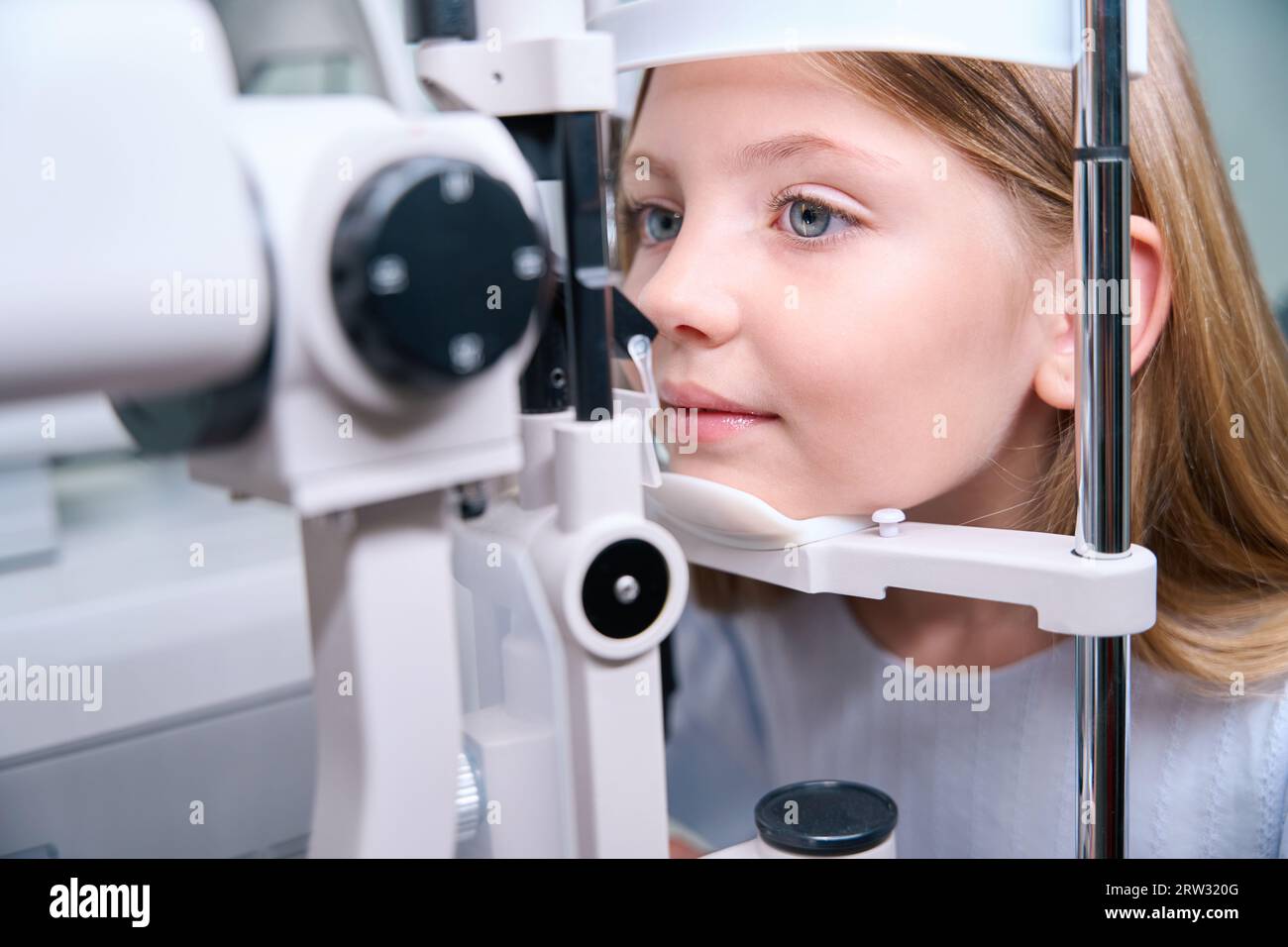 Pediatric patient undergoing eye examination on modern medical ...