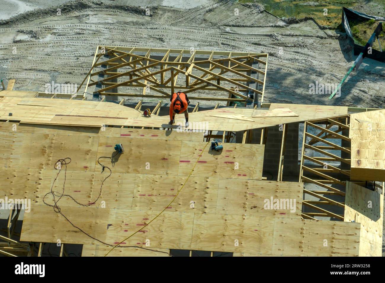 Aerial view of builders working on unfinished residential house with ...