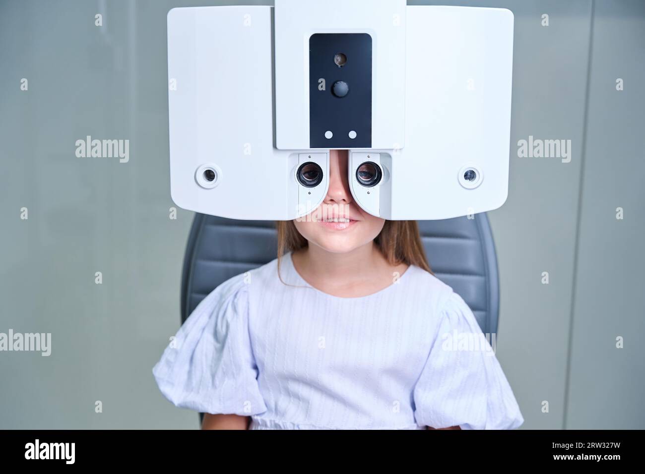 Child taking refraction test with modern optical equipment Stock Photo ...