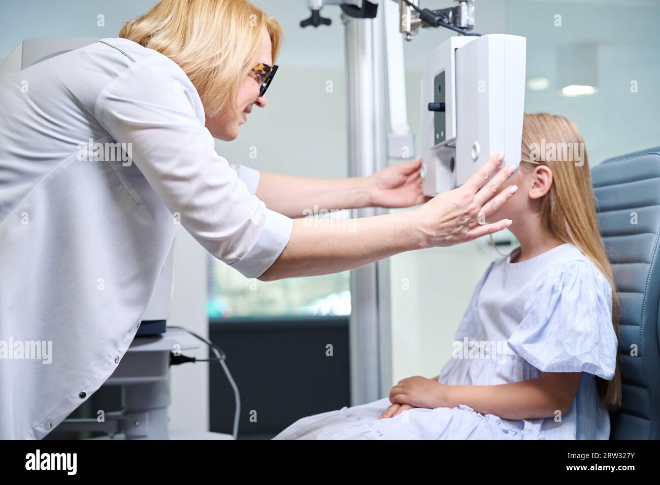 Experienced optometrist preparing child for binocular vision test Stock ...