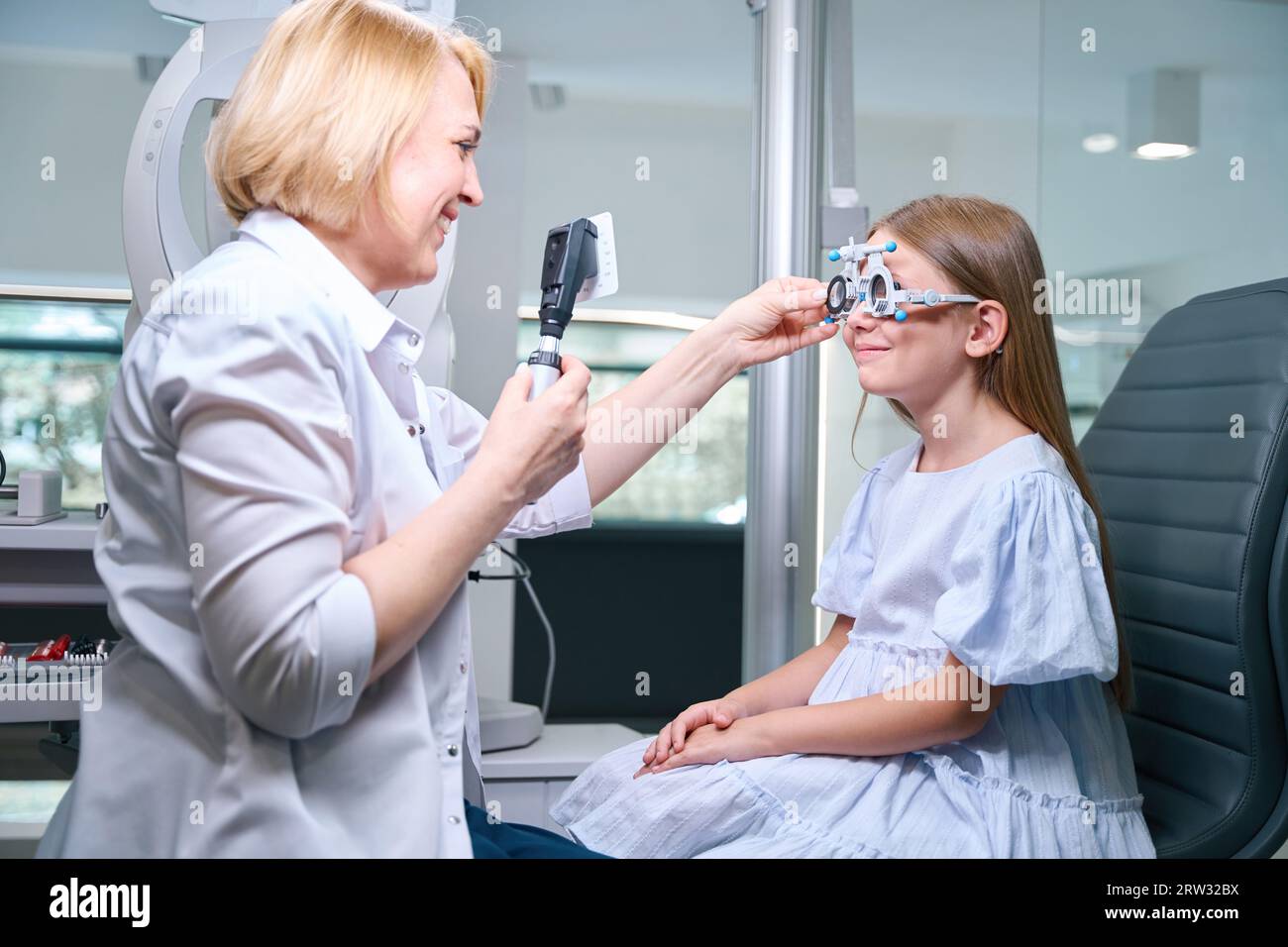 Friendly ophthalmologist performing dynamic retinoscopy on little ...