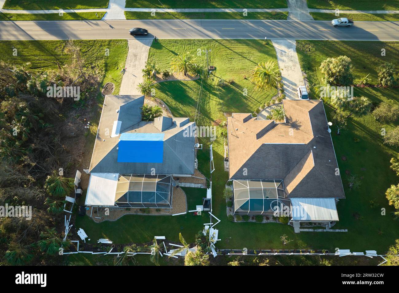 Aerial view of damaged in hurricane Ian house roof covered with blue ...