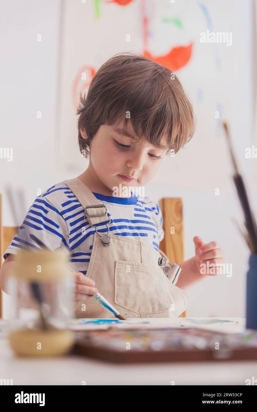 Child painting his work of art with his brush Stock Photo - Alamy