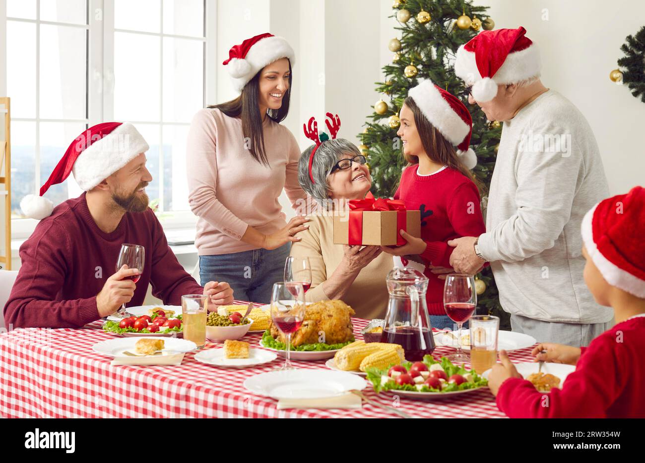 Happy family giving each other presents during a festive Christmas ...