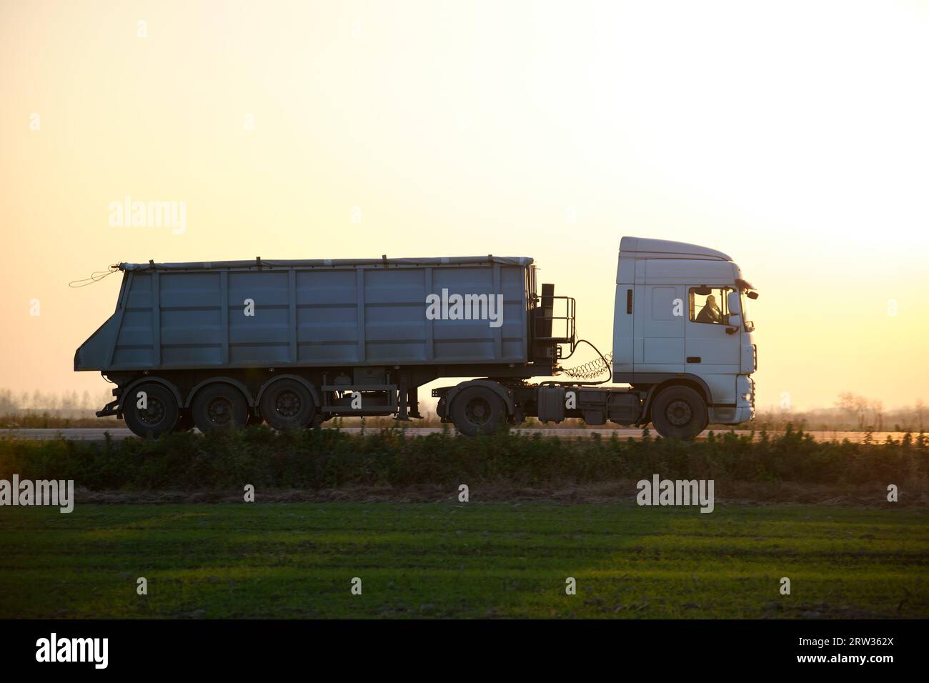 Semi-truck with tipping cargo trailer transporting sand from quarry ...