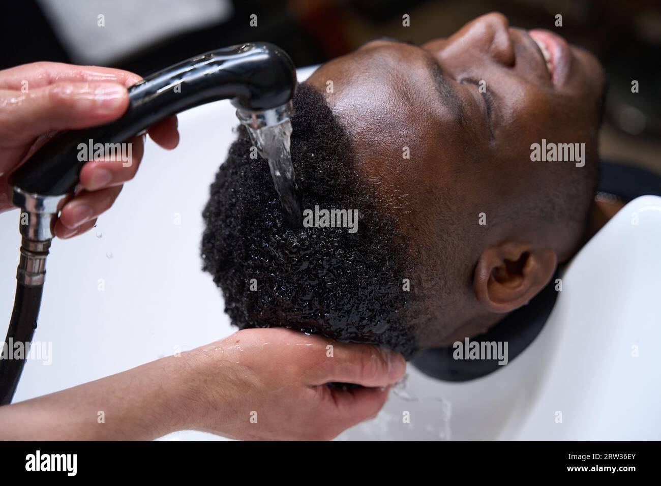 Barber washes the clients hair in a special sink Stock Photo - Alamy