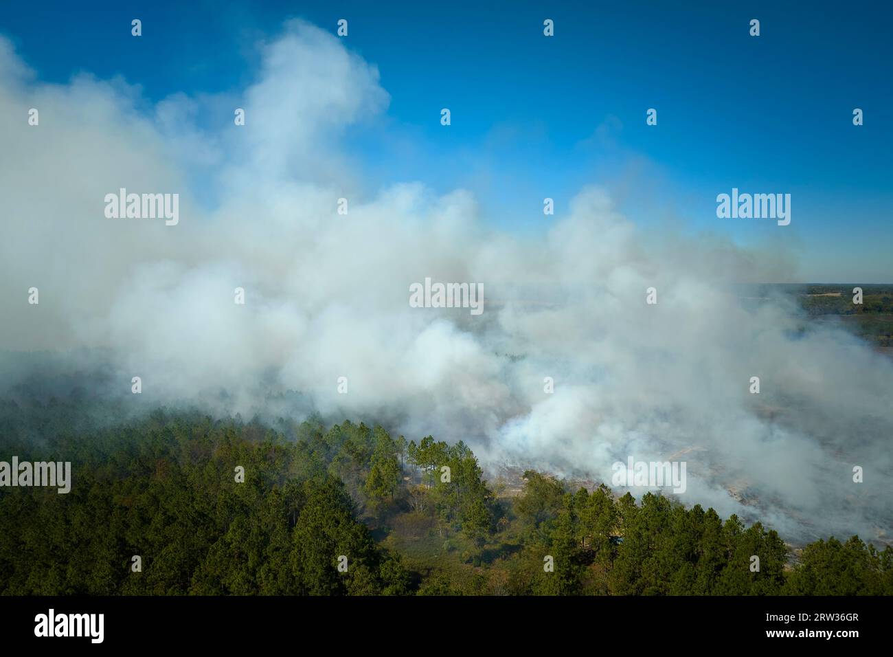 View from above of dense smoke from woodland and field on fire rising ...
