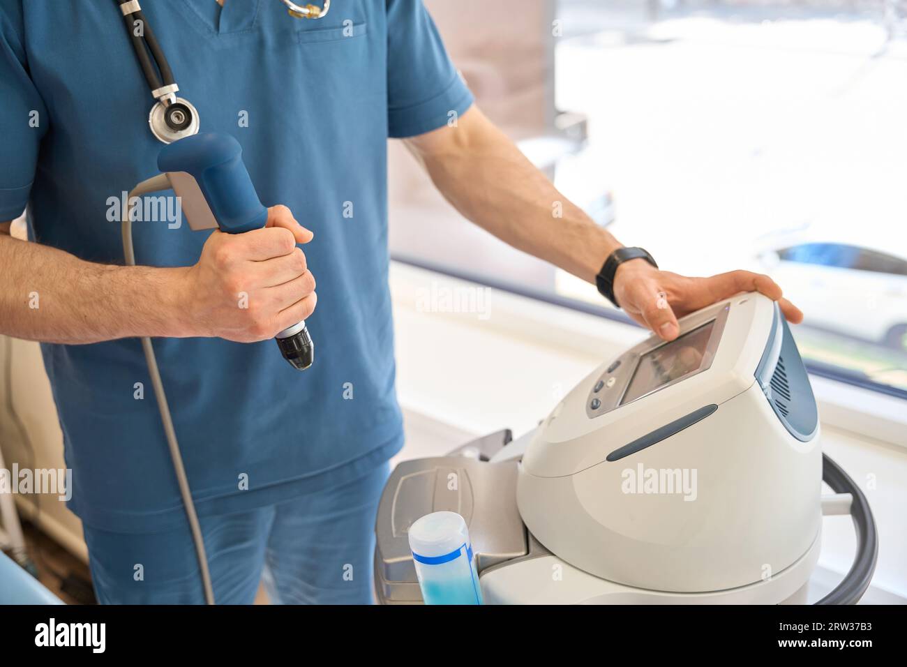 General practitioner adjusting extracorporeal shockwave therapy machine ...