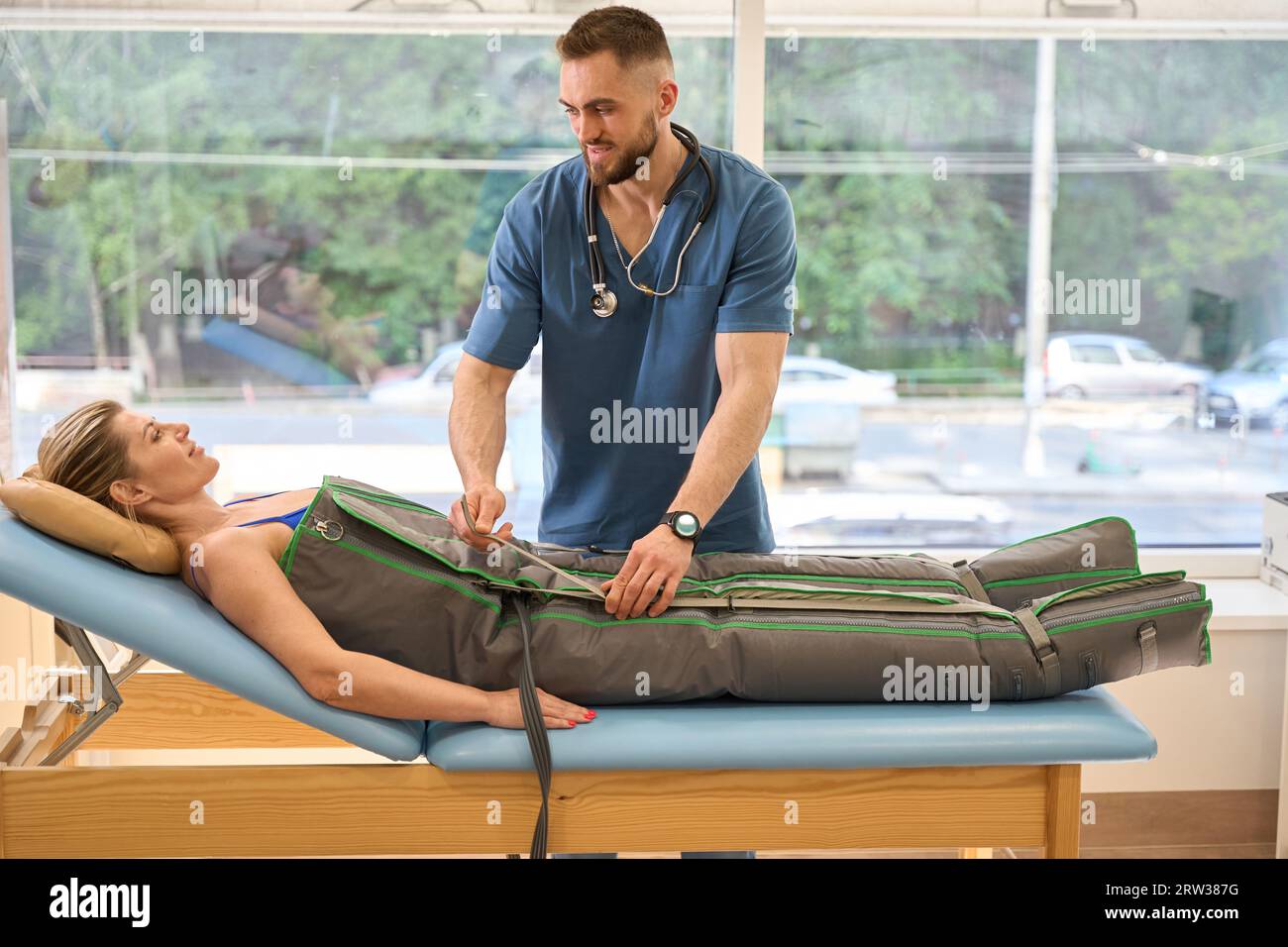 Confident woman attending pressotherapy procedure to relaxed muscles ...