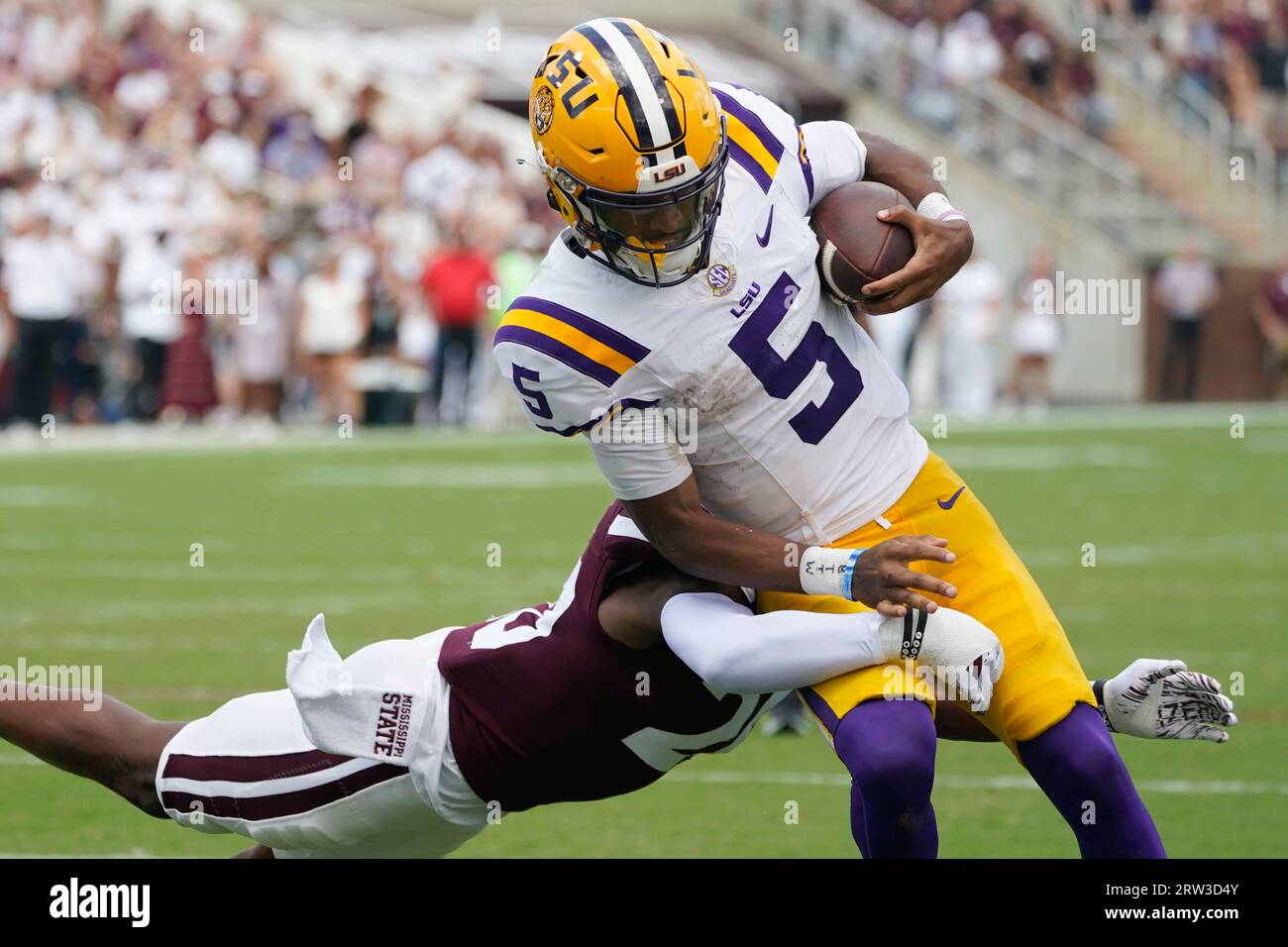 LSU quarterback Jayden Daniels (5) pushes through an attempted tackle ...