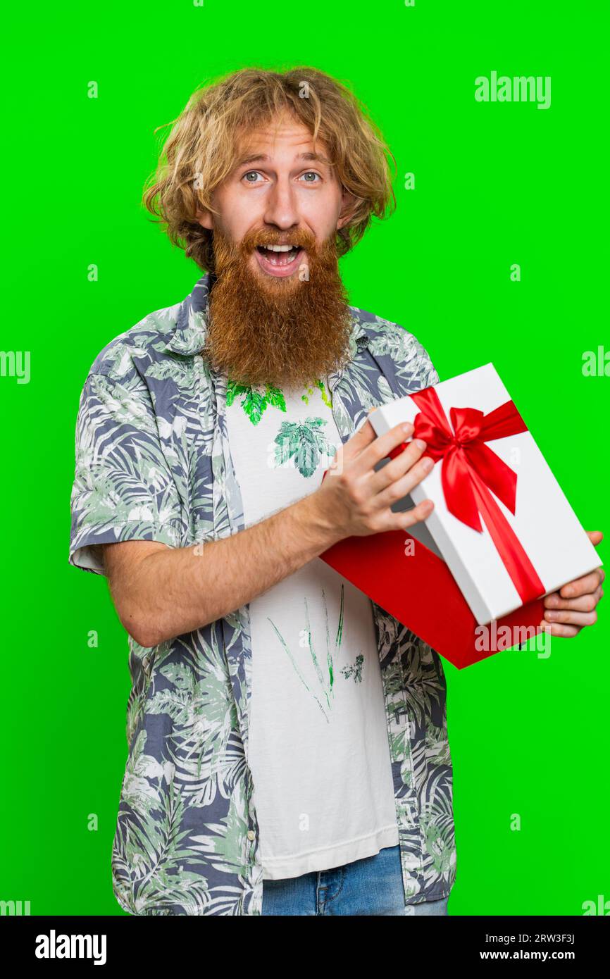 Happy caucasian man opening birthday gift box with red ribbon. Holidays ...