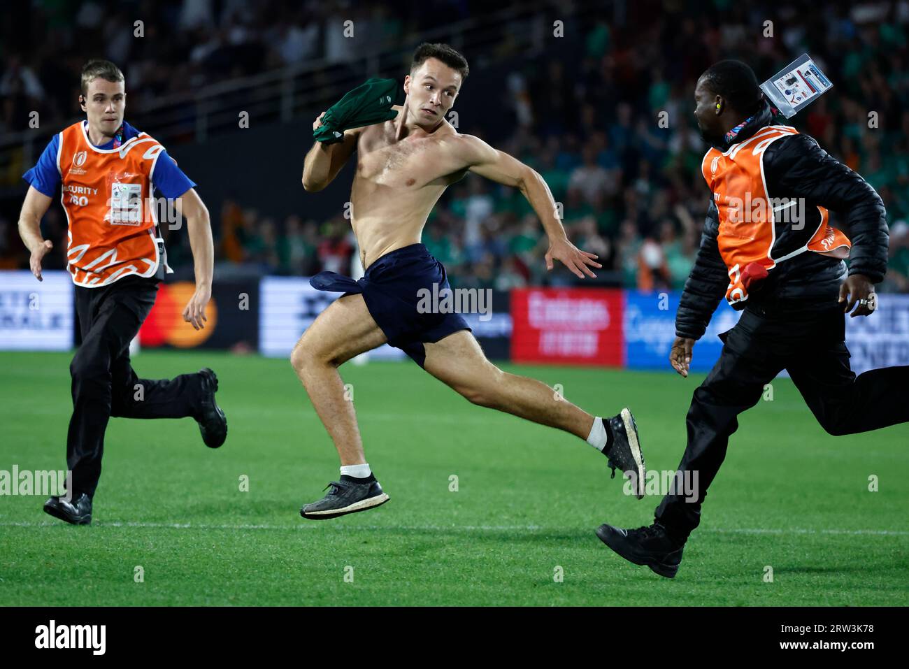 Security guards chase a pitch invader during the Rugby World Cup Pool B ...