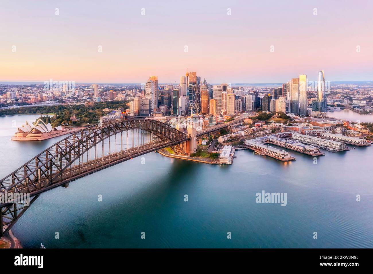 Mid-air scenic sunrise view over arch of Sydney harbour bridge across ...