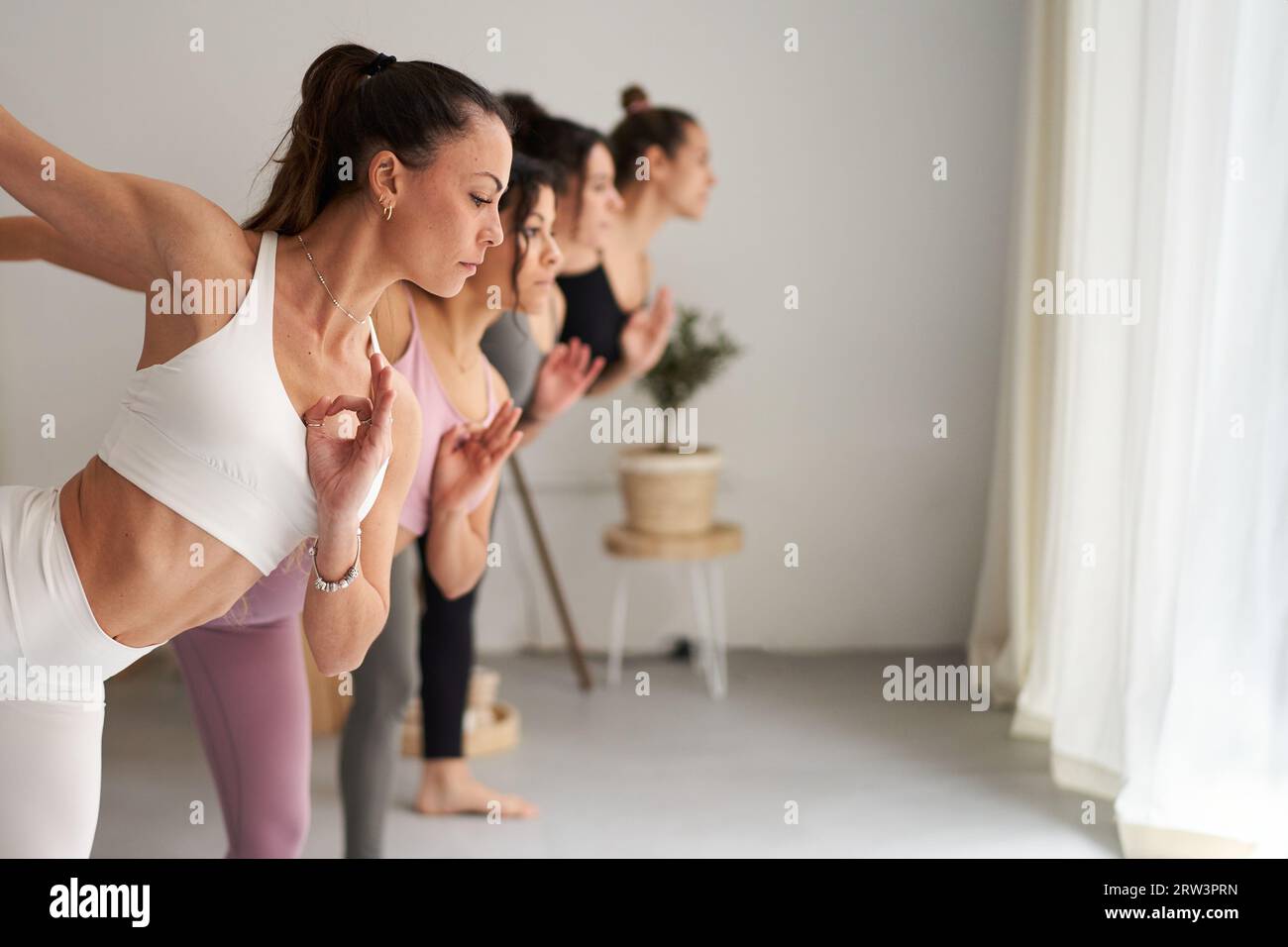 Group of Caucasian young people practicing yoga asanas indoors ...