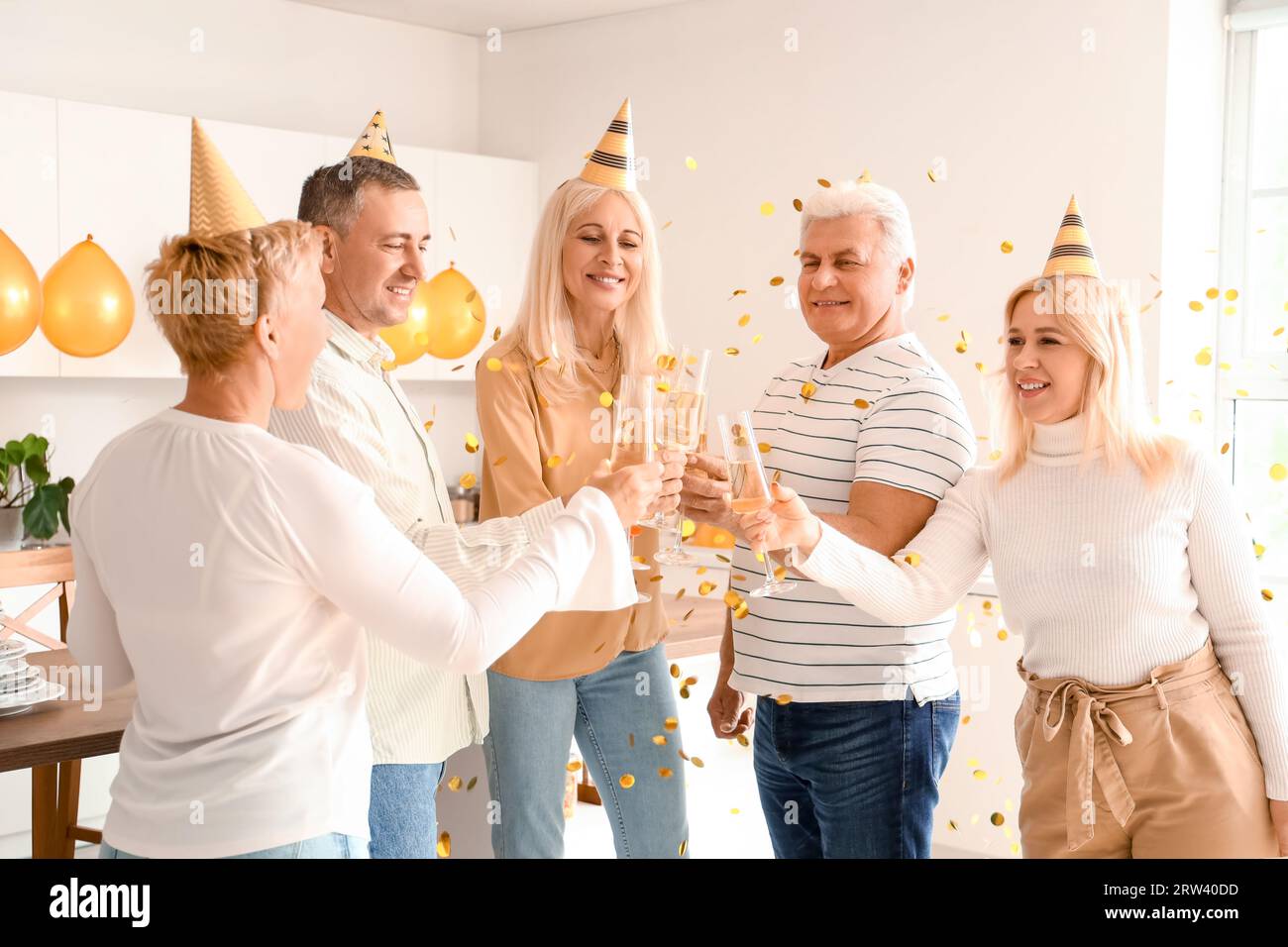 Mature people drinking champagne at Birthday party in kitchen Stock ...