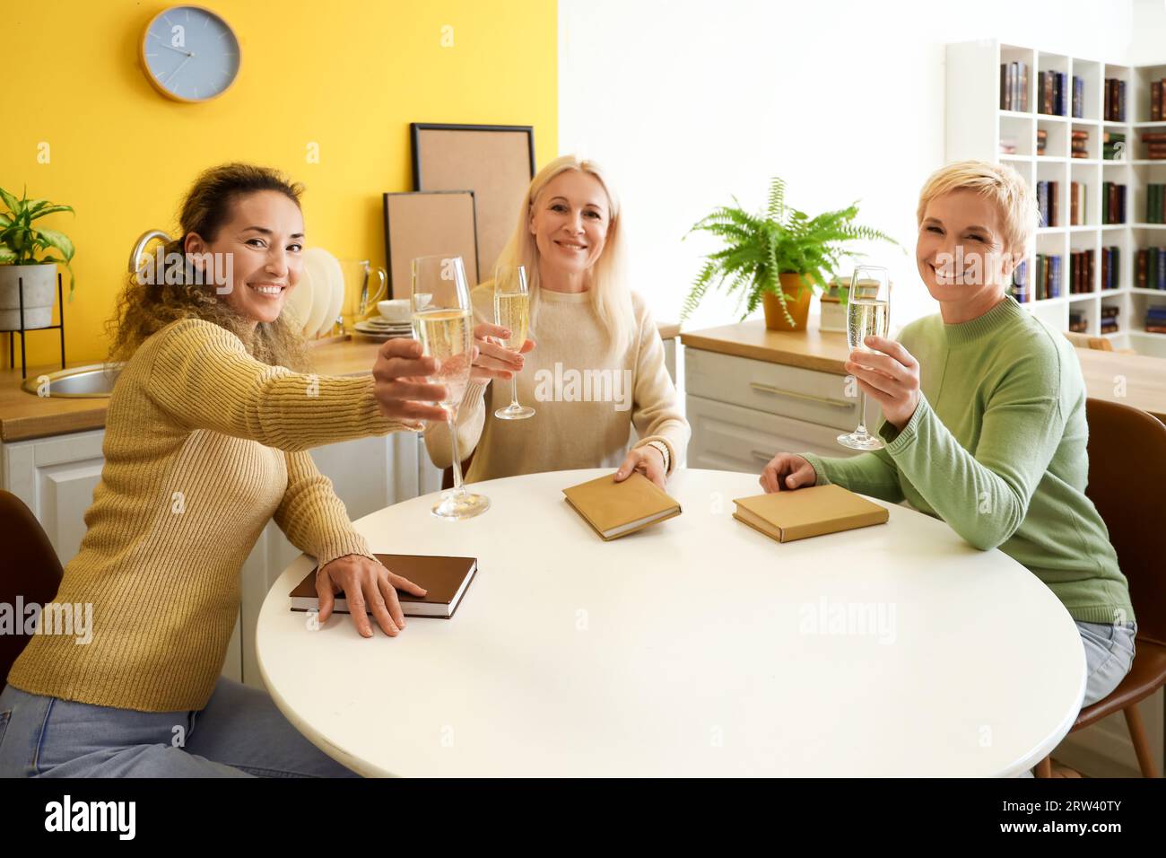 Mature women with champagne taking part in book club at home Stock ...