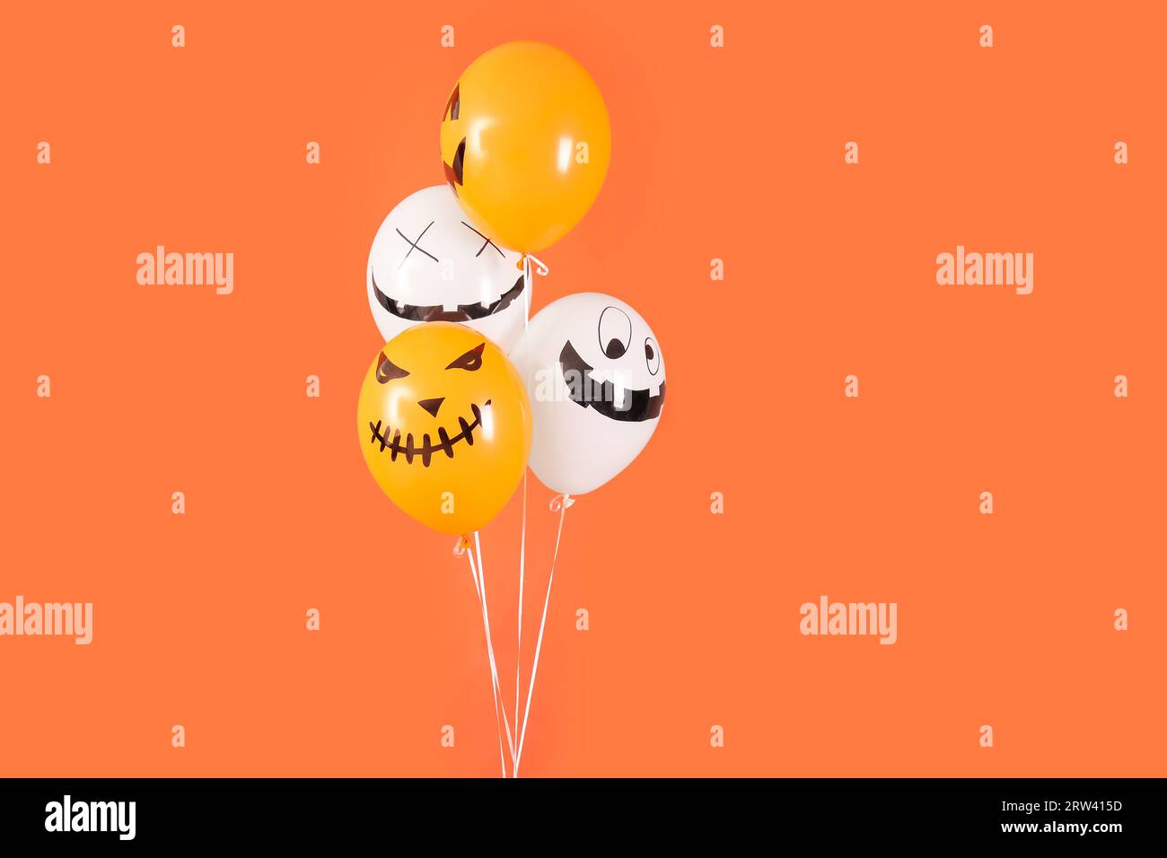 Different creepy Halloween balloons on orange background Stock Photo ...