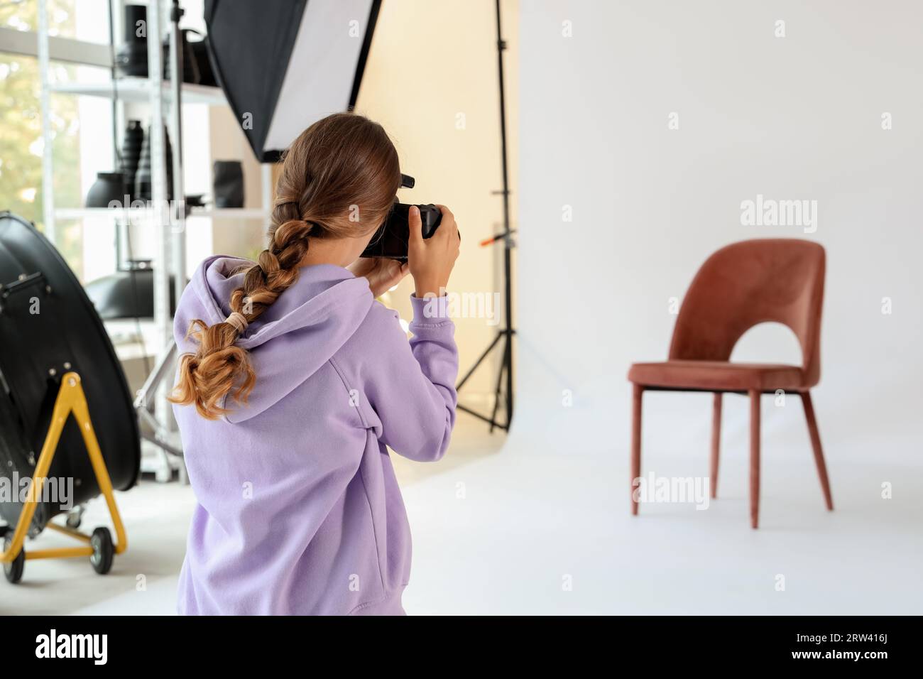 Female photographer taking picture of chair in studio Stock Photo - Alamy