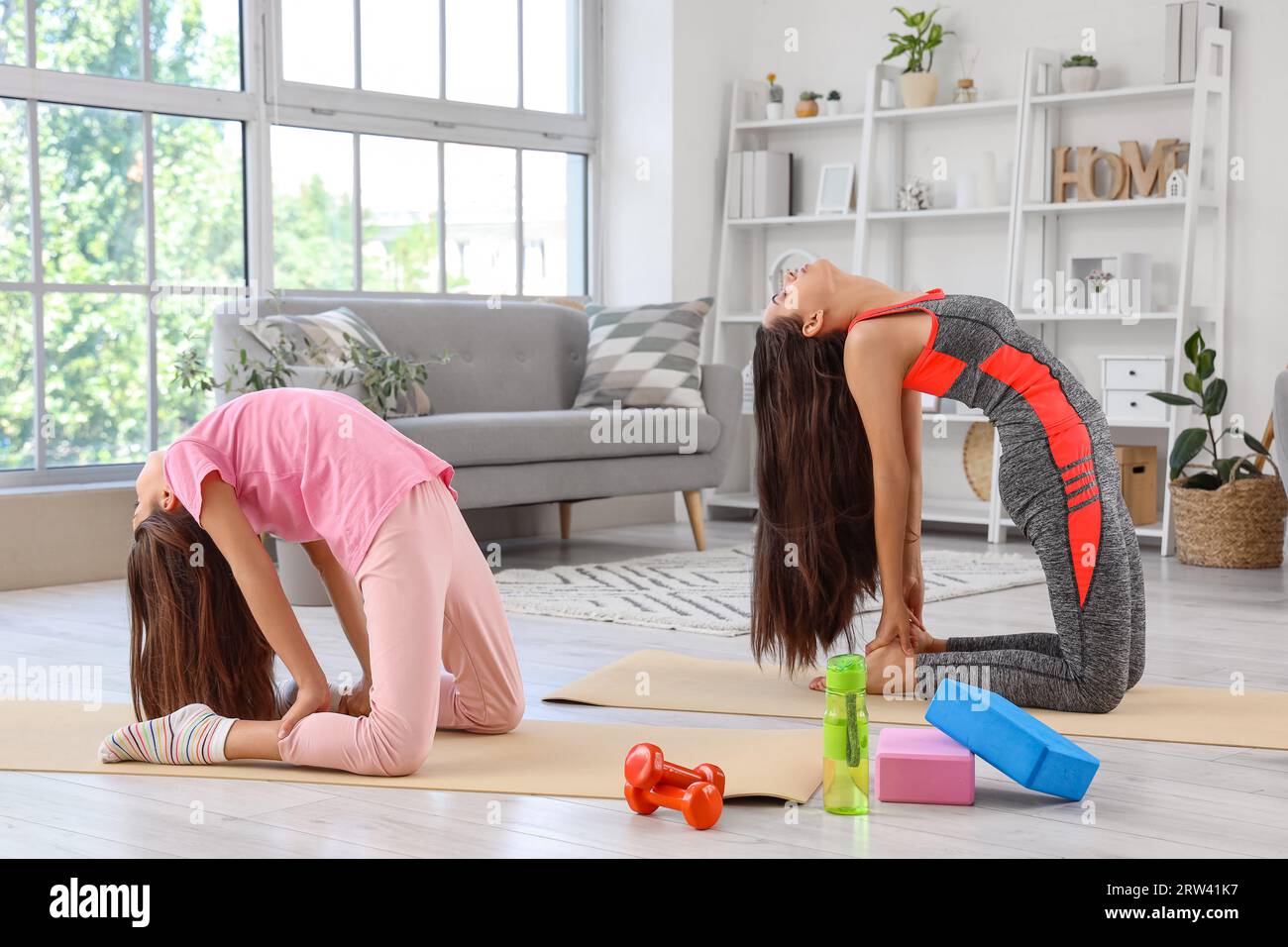 Sporty mother with her little daughter training at home Stock Photo - Alamy