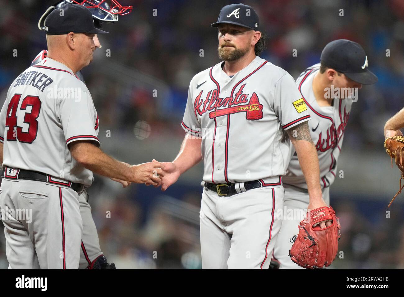 Atlanta Braves relief pitcher Kirby Yates, right, hands the ball to ...