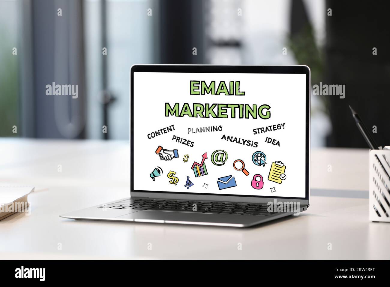 Email marketing. Laptop with icons on screen in office Stock Photo - Alamy