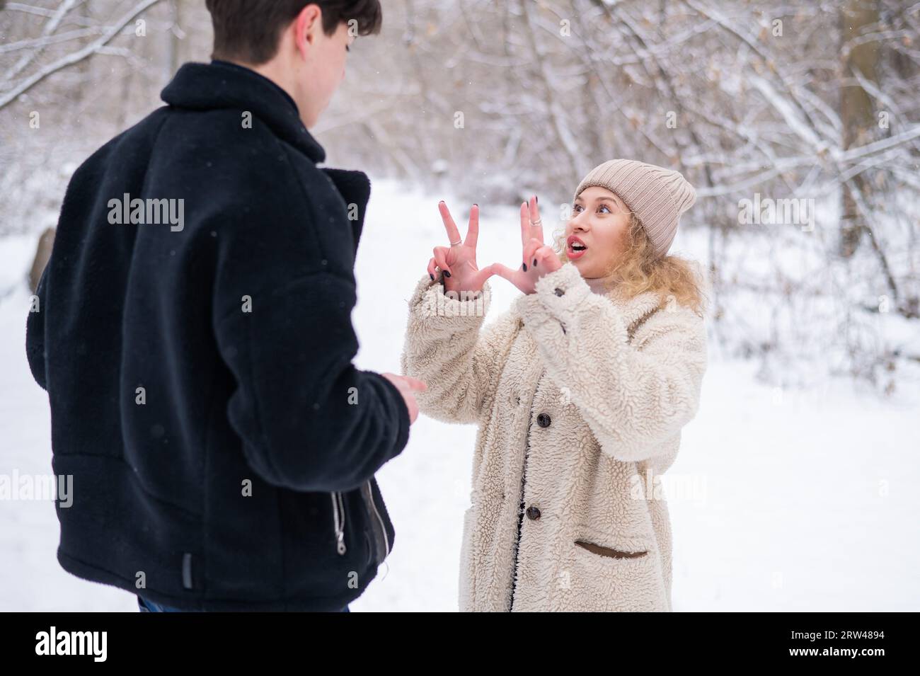 A young couple walks in the winter in the forest. Deaf Guy and a girl ...