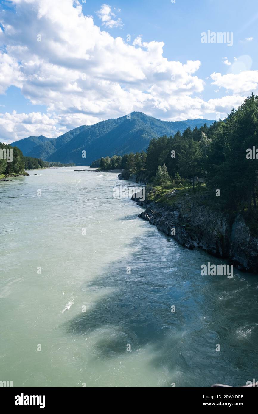 A wide, full-flowing mountain river with a fast current Stock Photo - Alamy