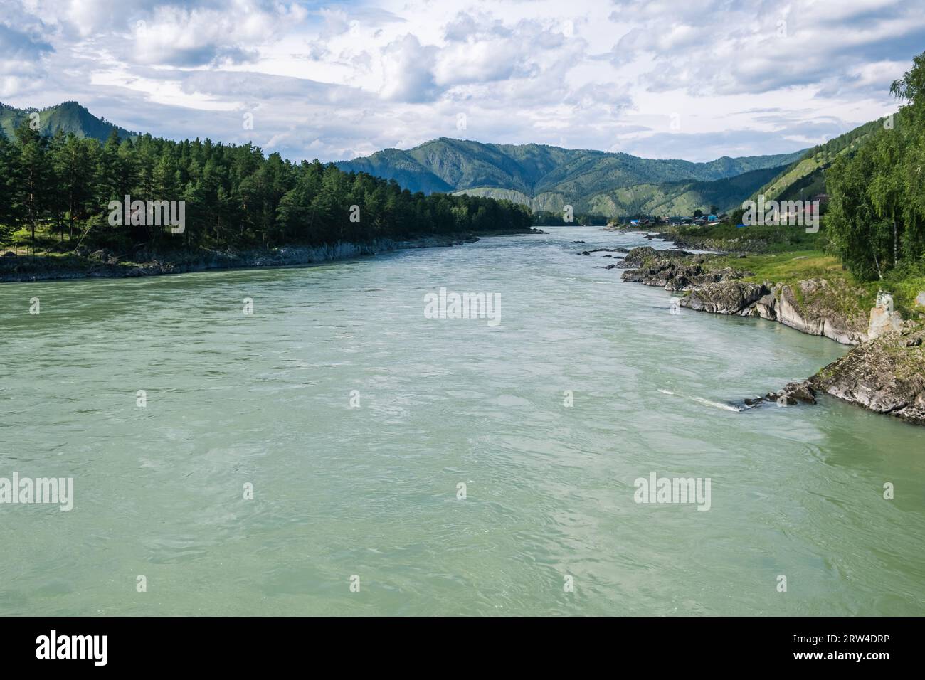 A wide, full-flowing mountain river with a fast current Stock Photo - Alamy
