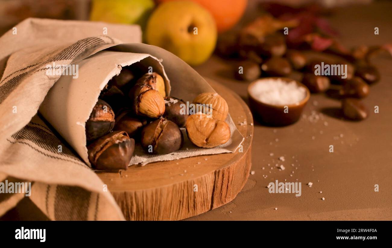 Roasted chestnuts in a paper cone, on a rustic kitchen countertop Stock ...