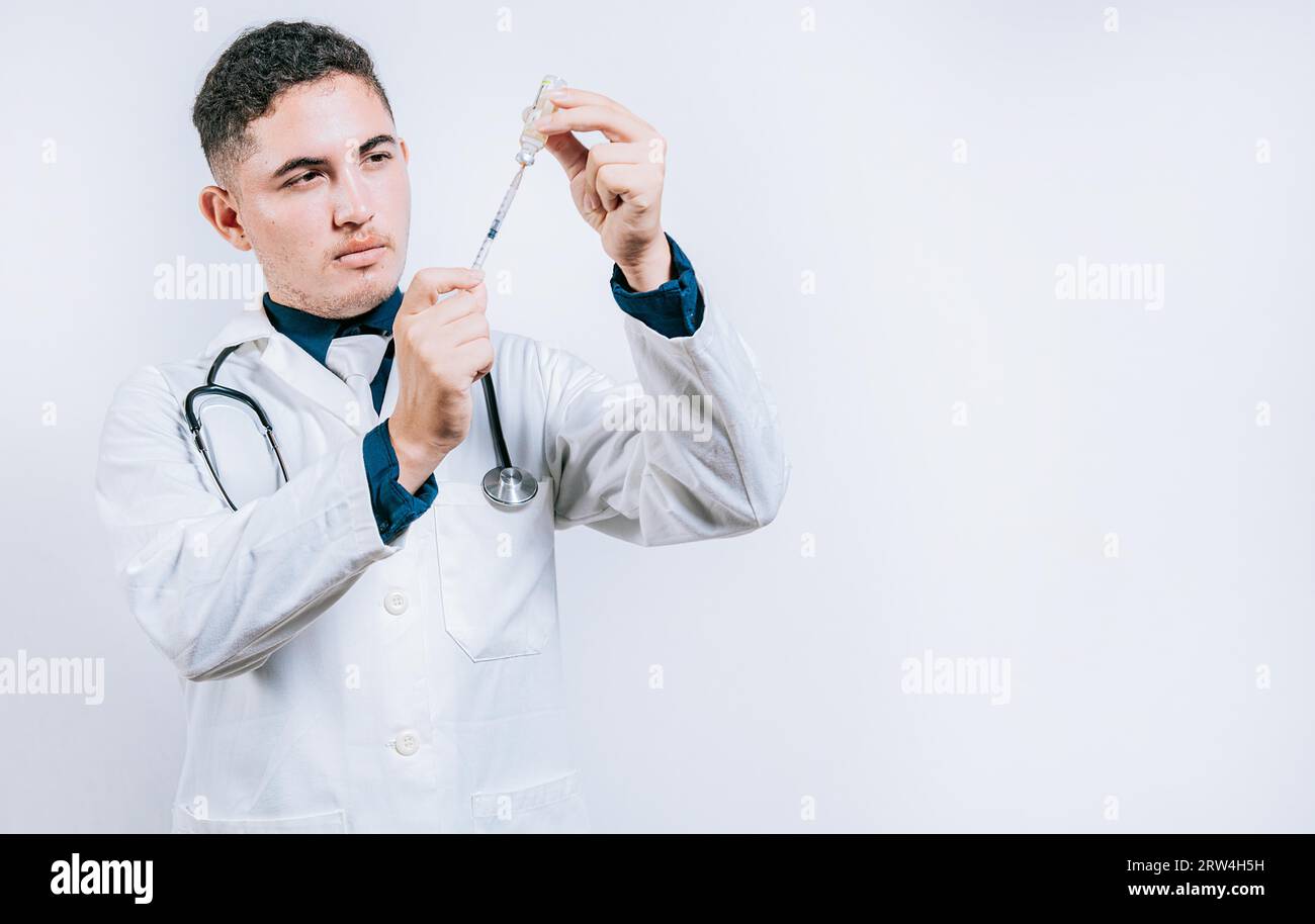 Handsome doctor drawing medicine from a vial with copy space. doctor ...