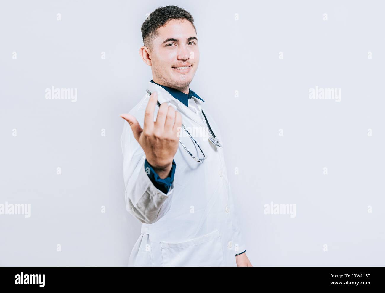 Young friendly doctor inviting to come on white background. Smiling ...