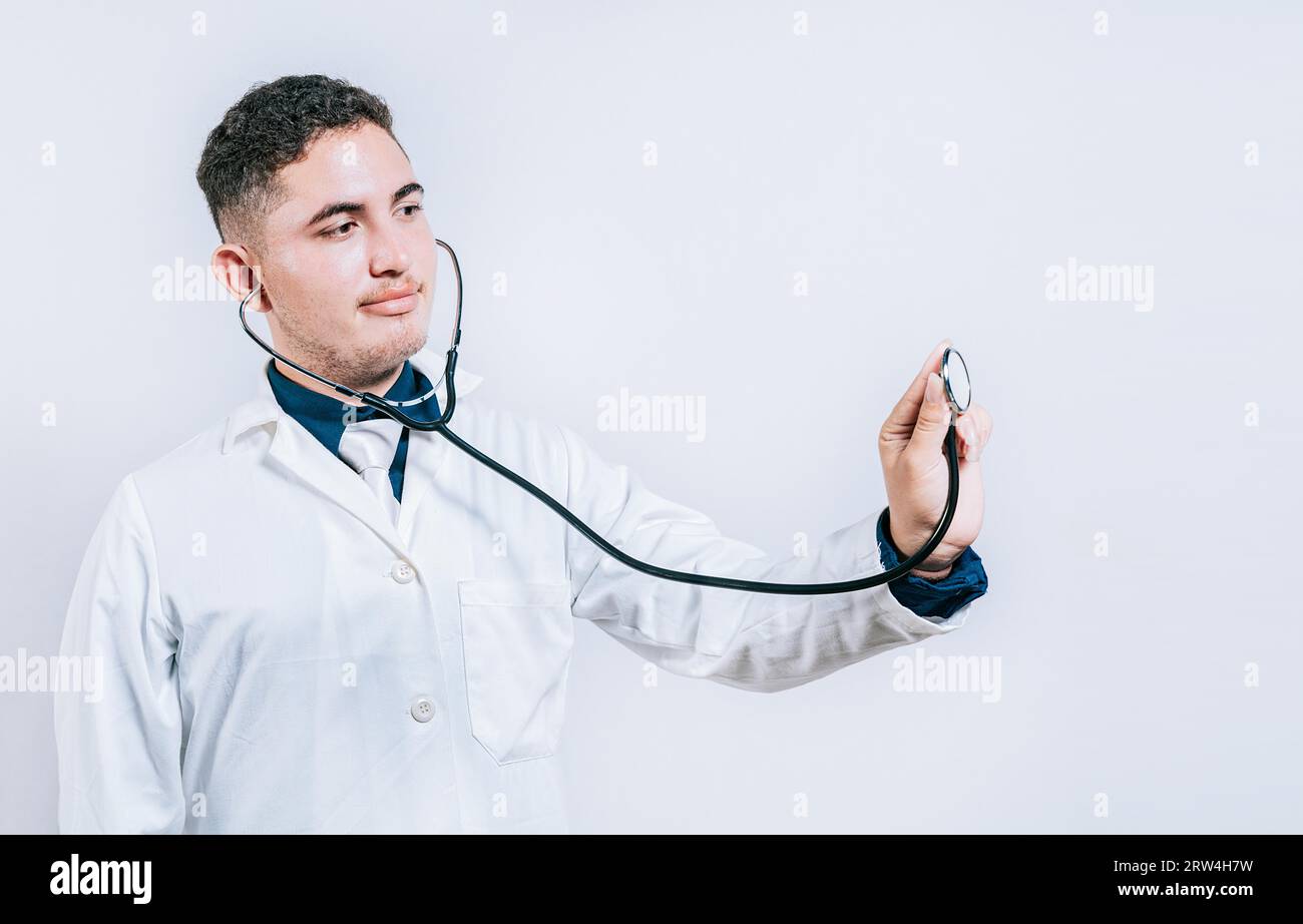 Male doctor holding stethoscope on white background. Portrait of latin ...