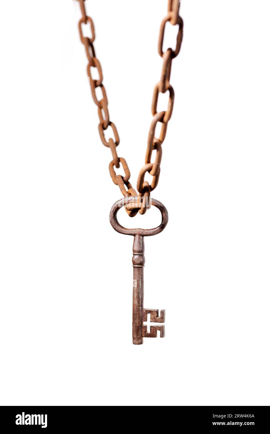 Old big key hanging from a rusty chain. Very short depth-of-field, the ...